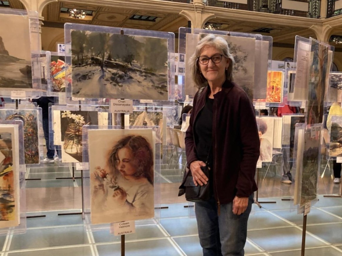 Image: Colleen Helmore with her painting "WONDER" (bottom left)